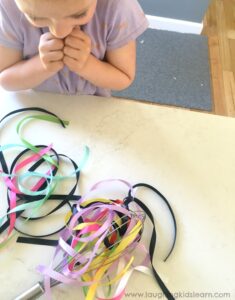 Fine motor ribbon and whisk activity - Laughing Kids Learn